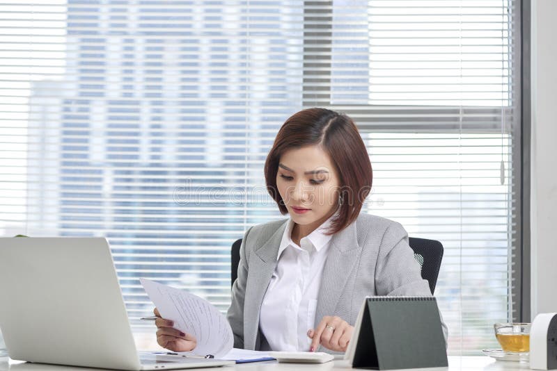Financial Advisor Using Calculator Review Financial Statement on Desk ...
