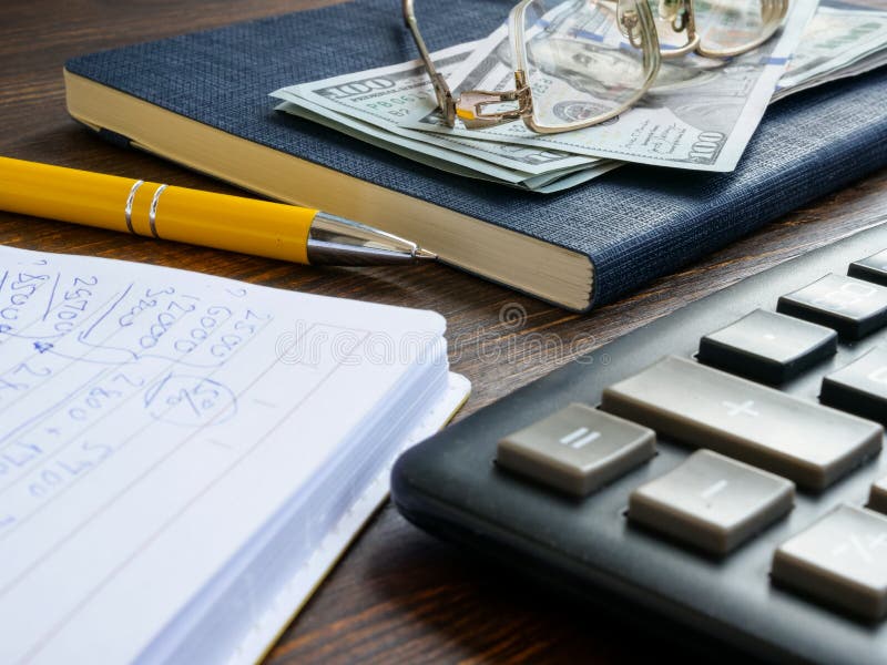 Calculator And Notepad With Calculations After Counting Money Stock