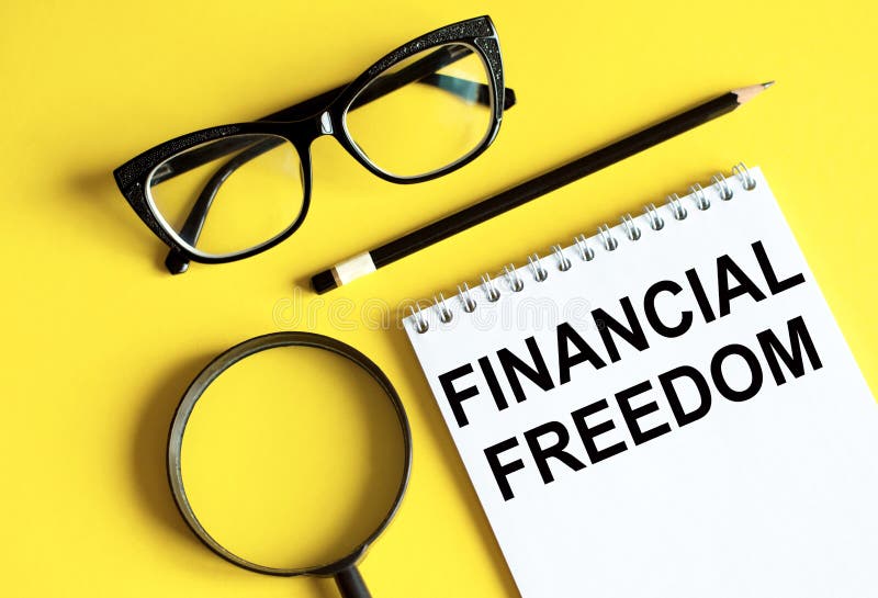 FINANCIAL FREEDOM Text Written on a Notebook with Glasses, Magnifying ...