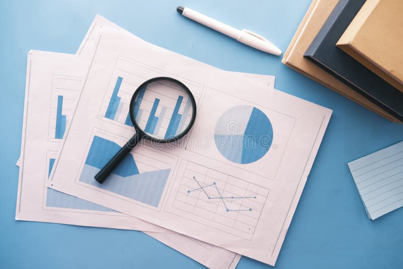 Financial Graph, Magnifying Glass and Notepad on Table Stock Photo ...