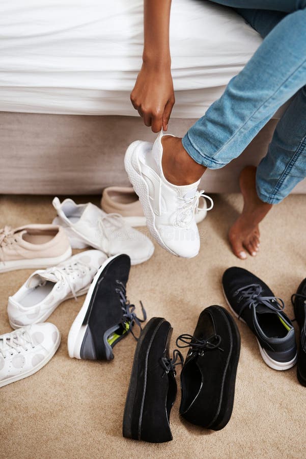 Finding the Right Fit. a Woman Trying on Different Pairs of Shoes at ... Finding the Right Fit. a Woman Trying on Different Pairs of Shoes at ...