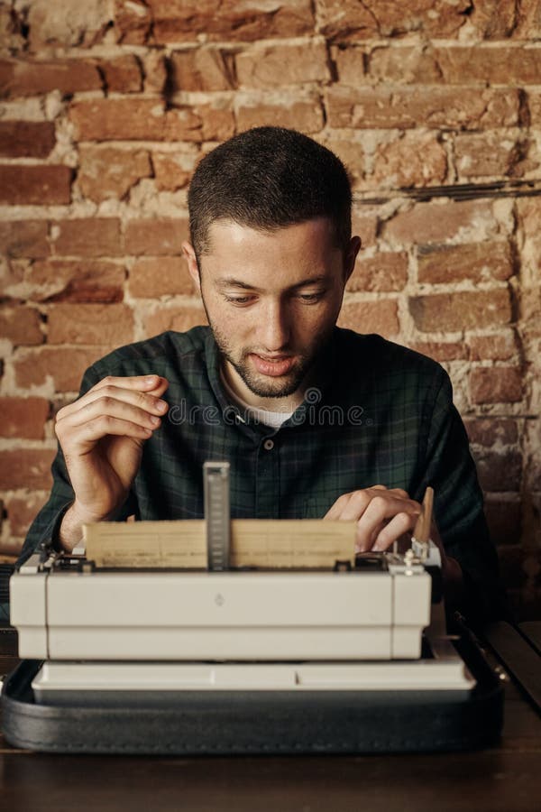 Fine Young Writer Working on a Classic Typewriter. he is Happy and in ...