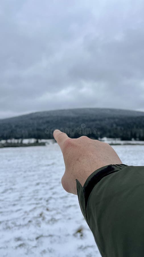 A Finger of a Hand Points To a Mountain Peak in Winter Stock Photo ...