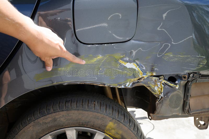 Finger Pointing at Dents on Car from Accident, Damage on the Back Side ...