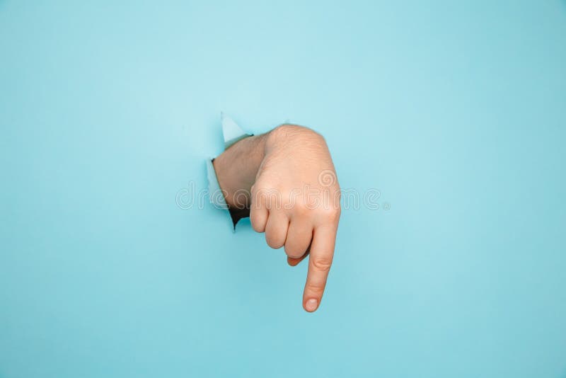 Finger Pointing Down through Torn Blue Paper Wall. Hand Gestures of ...