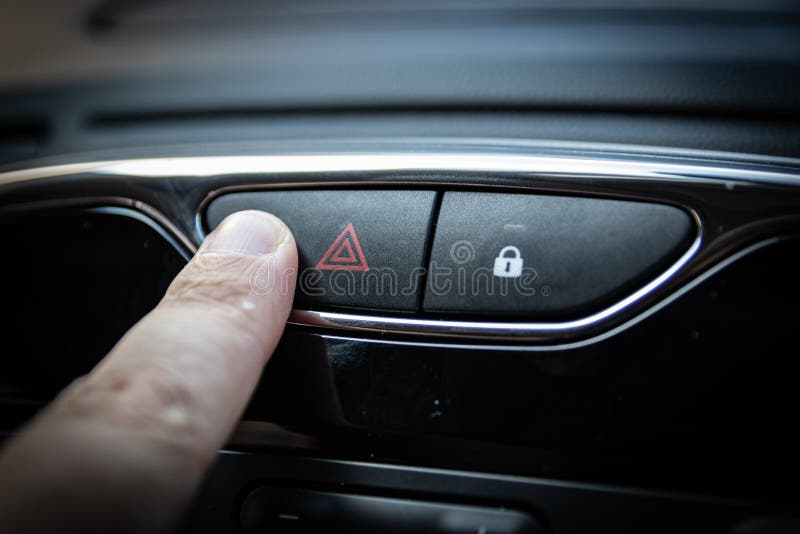 A Finger Pressing a Hazard Warning Light on the Interior of a Car Stock ...