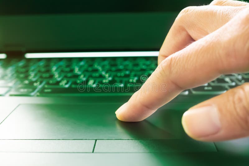Finger on Touchpad Keyboard Laptop Computer with Green Over Light ...