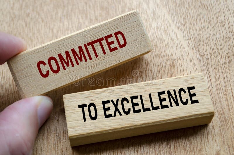 Fingers Align Wooden Blocks that Declare Commitment To EXCELLENCE ...