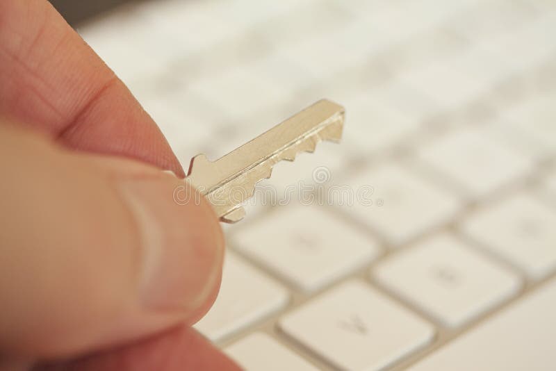 Fingers Holding a Key in Front of a Computer Keyboard. PC Network ...