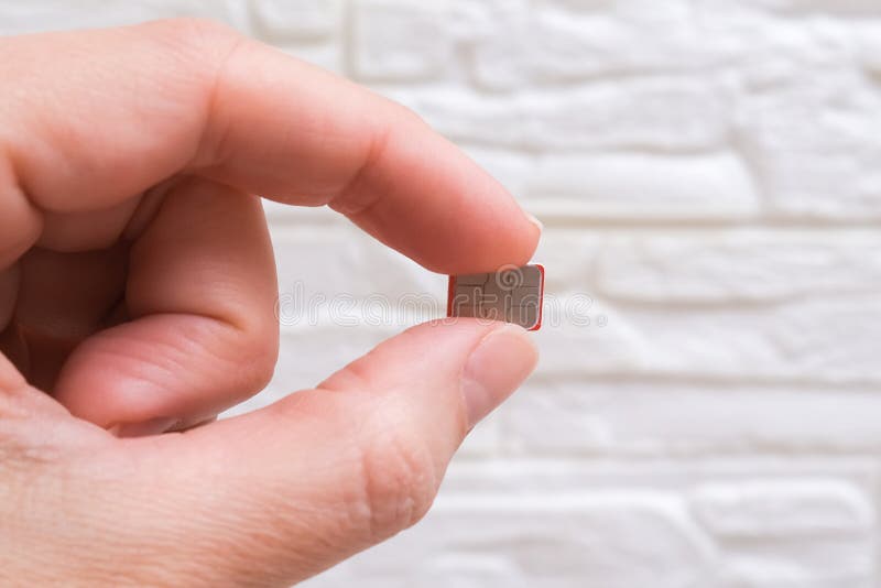 Micro Sim Card for Mobile Communication on a Finger Close Up, Wireless ...