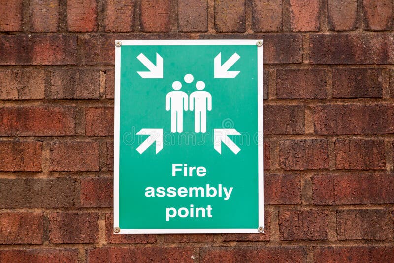 A Fire Assembly Point Sign on a Brick Wall Stock Photo - Image of ...