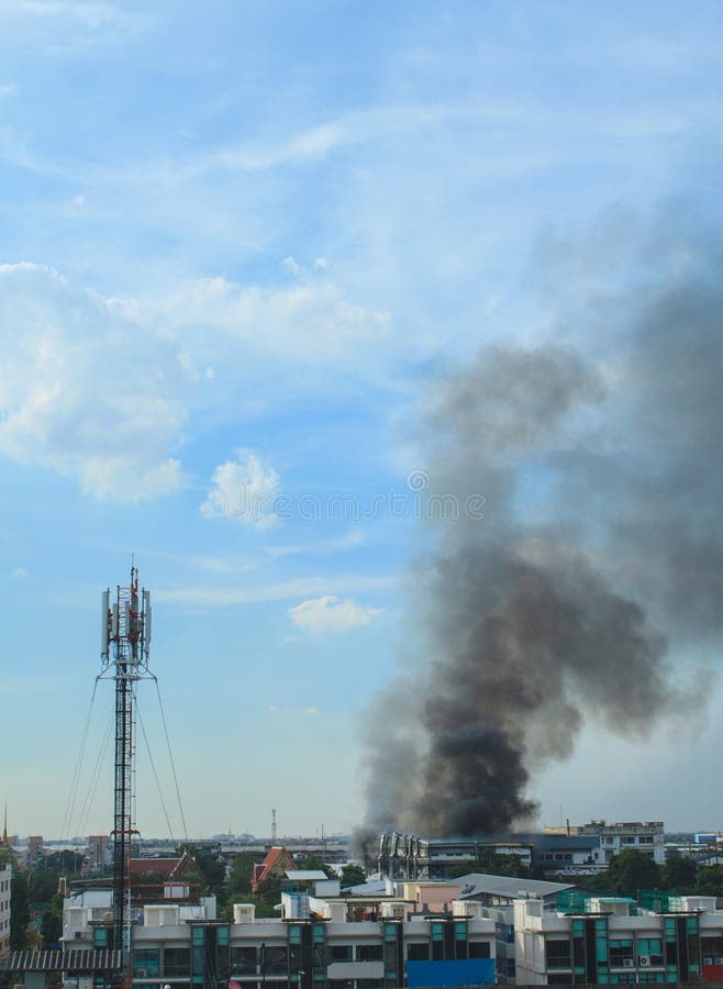 A Burning Factory Causes a Big Pile of Dark, Black Smoke on a Sky ...
