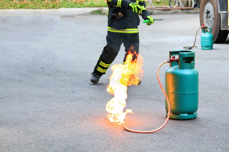 Fire Burning on Green Gas Container with Firefighter or Fireman in ...