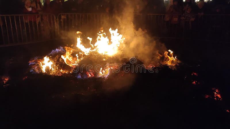 A Fire of Burning Hay is Doused with a Stream of Water at Night Stock ...