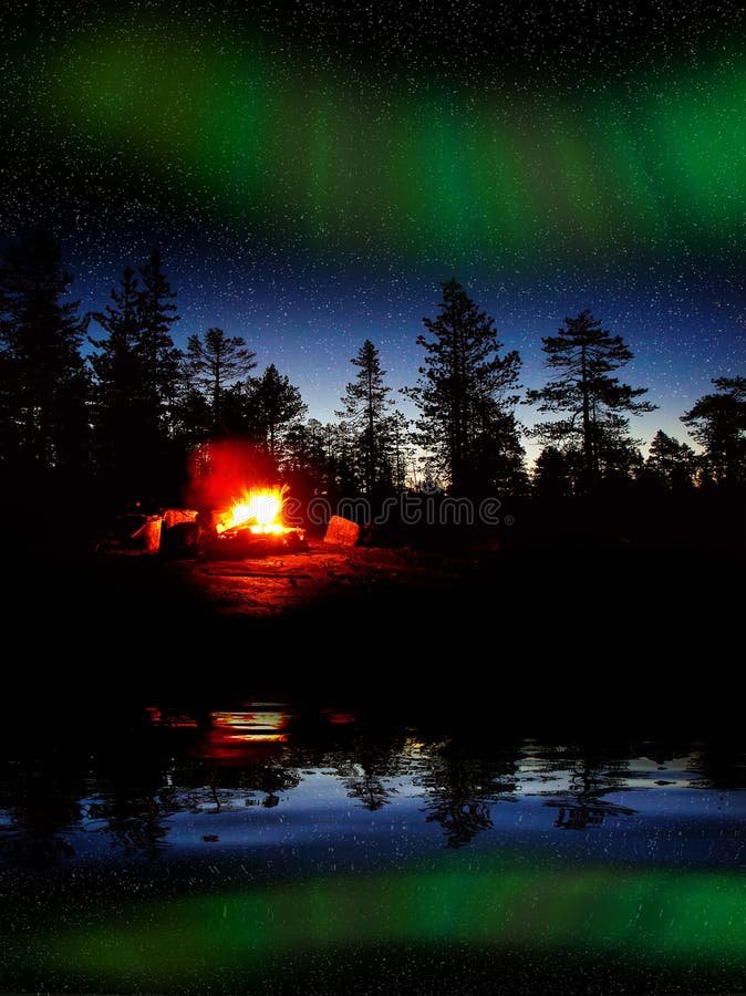 Fire Burning at Night in a Forest with Northern Lights Stock Photo ...
