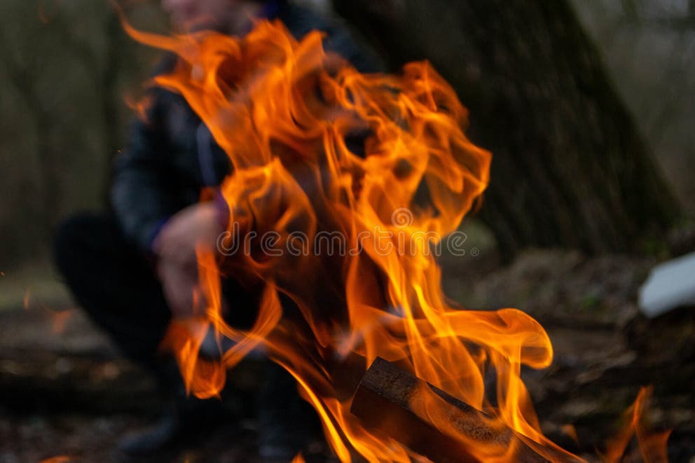A Fire Burns in a Campfire with a Red Fire in the Background. Stock ...