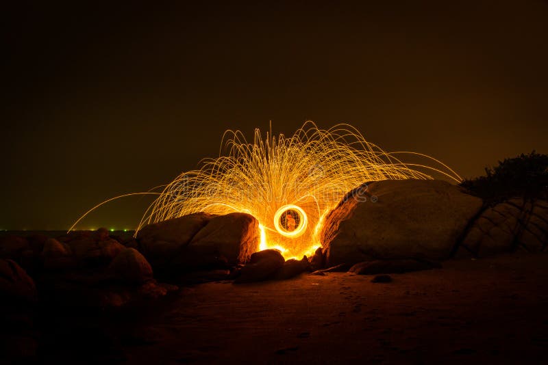 Fire Dancer Swing Fire Dancing Show on the Beach with Dark Clouds ...