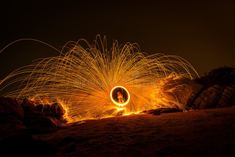 Fire Dancer Swing Fire Dancing Show on the Beach with Dark Clouds ...