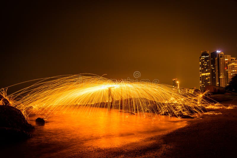 Fire Dancer Swing Fire Dancing Show on the Beach with Dark Clouds ...