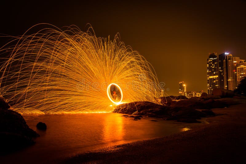 Fire Dancer Swing Fire Dancing Show on the Beach with Dark Clouds ...
