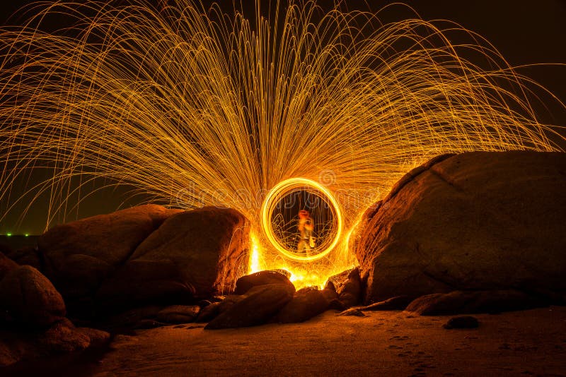 Fire Dancer Swing Fire Dancing Show on the Beach with Dark Clouds ...