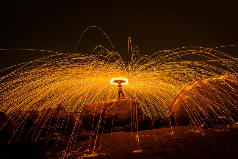 Fire Dancer Swing Fire Dancing Show on the Beach with Dark Clouds ...