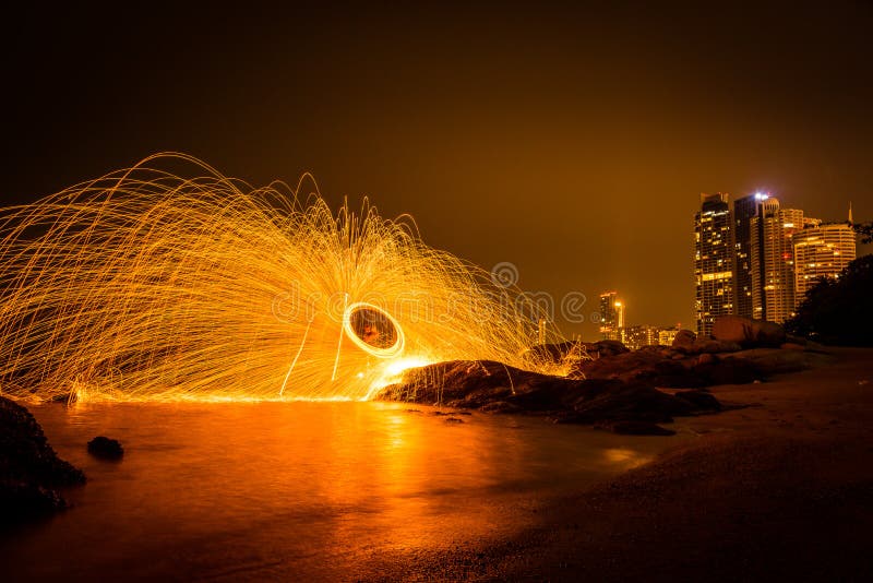 Fire Dancer Swing Fire Dancing Show on the Beach with Dark Clouds ...