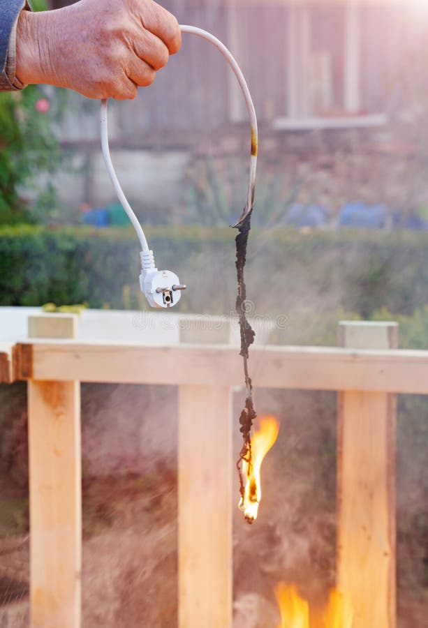 Fire on an Electric Wire with a Plug in the Hands of a Man. Stock Photo ...