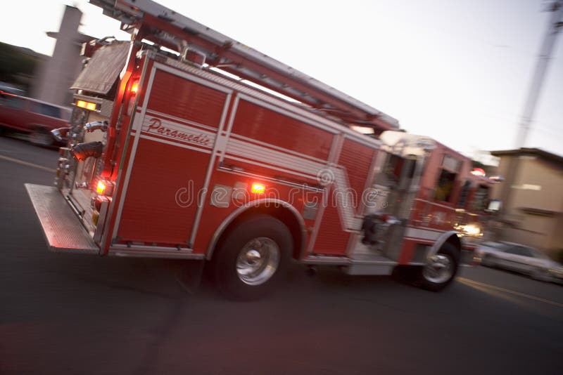 Fire Engine Driving Down Street Stock Photo - Image of answering ...