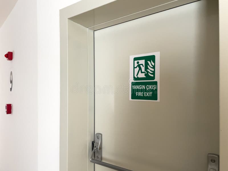Fire Exit Door with a Green Emergency Sign in a Modern Building. Stock ...