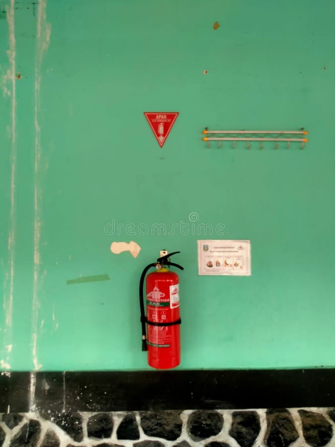 The Fire Extinguisher with Caution Hang on the Blue Wall Editorial ...