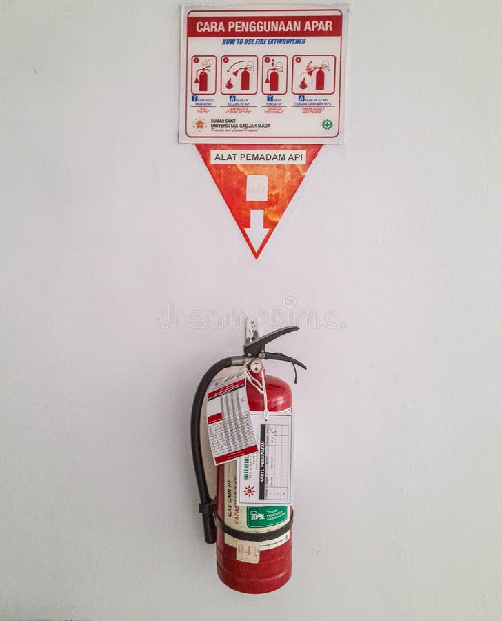 Fire Extinguisher Mounted on Wall with Safety Sign Above in ...