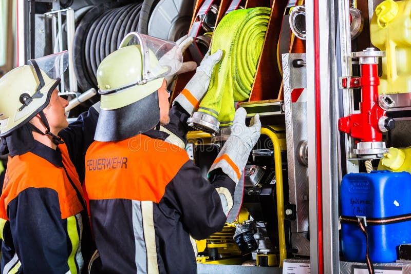 Fire Fighters Loading Hoses into Operations Vehicle Stock Photo - Image ...