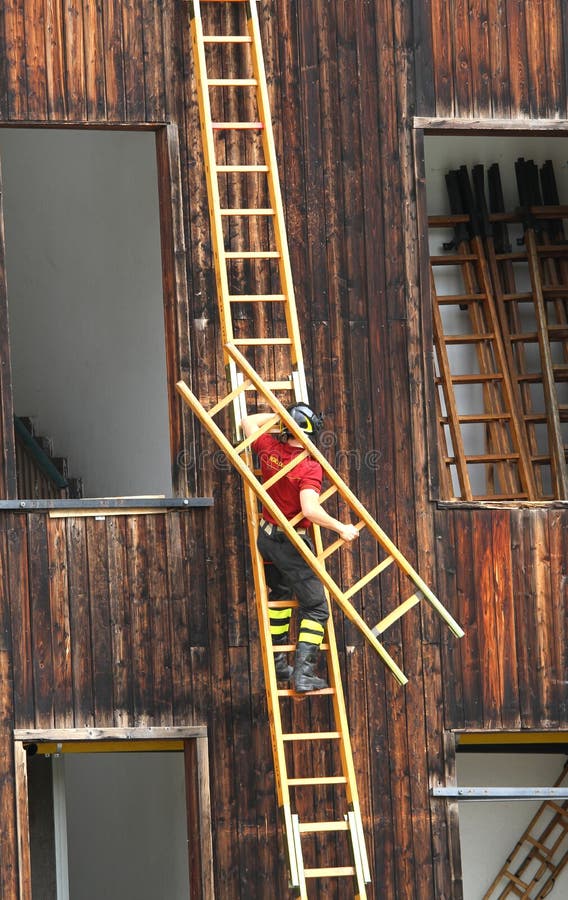 Firefighter on the Wooden Ladder Enters the Window in the Fire S Stock ...