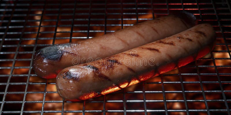 Fire Going on the Barbecue with a Pair of Hot Dogs Cooking Stock Photo ...