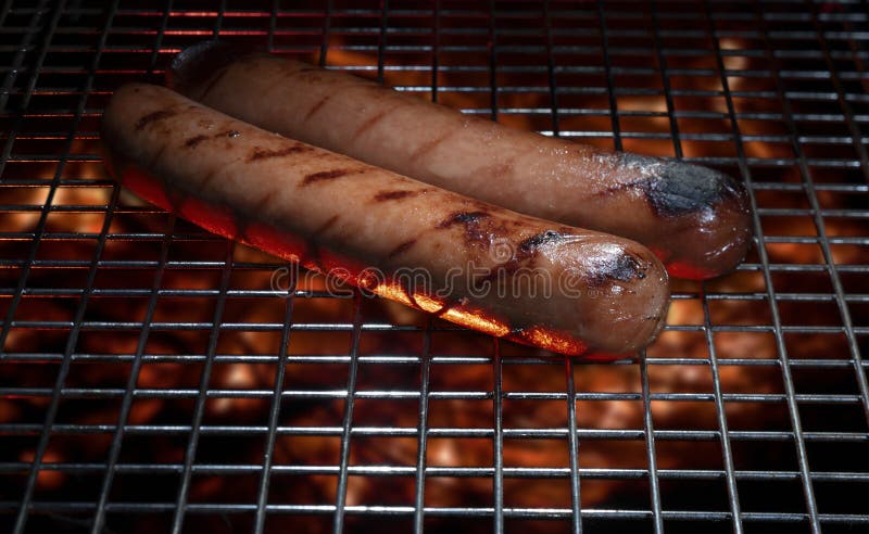 Fire Going Under a Pair of Hot Dogs on the Grill Stock Image - Image of ...