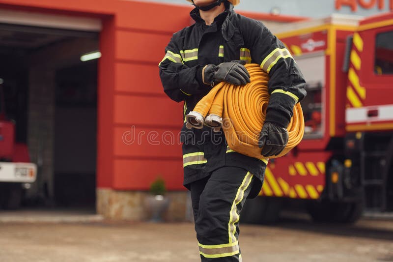 With Fire Hose in Hands. Woman in Uniform is at Work in Department ...