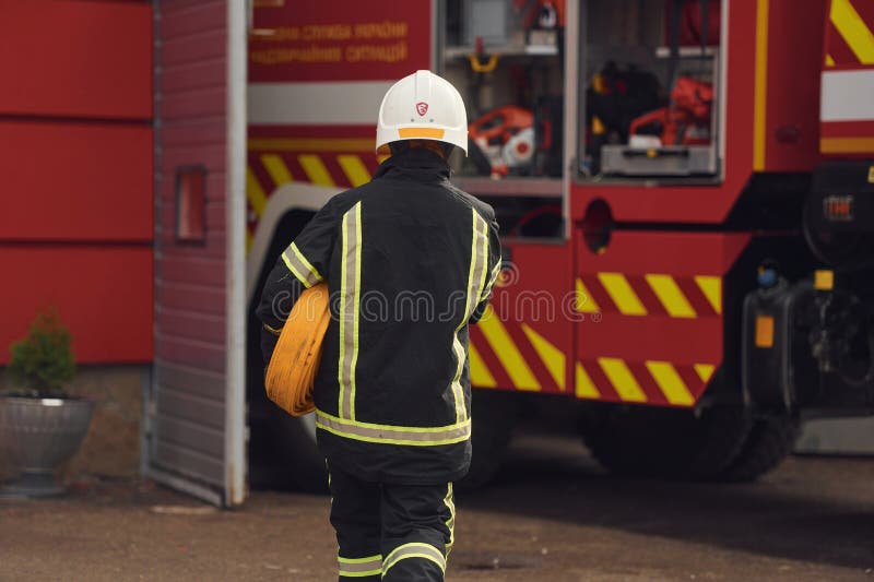 With Fire Hose in Hands. Woman in Uniform is at Work in Department ...