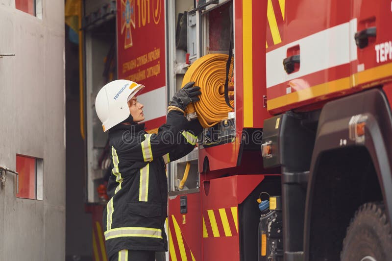 With Fire Hose in Hands. Woman in Uniform is at Work in Department ...