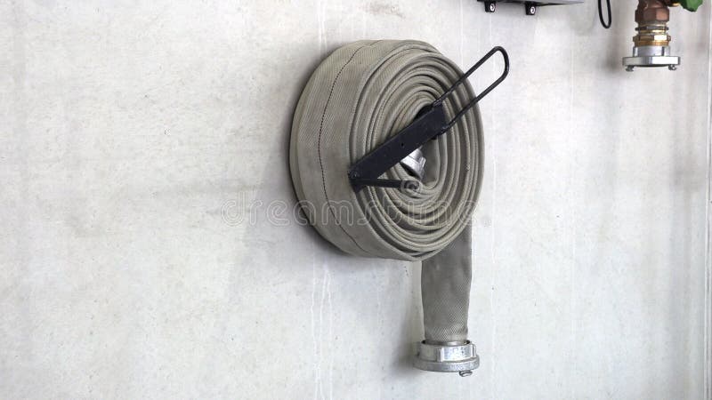 Fire Hose Reeled Up Hanging on the Wall Stock Video - Video of gear ...