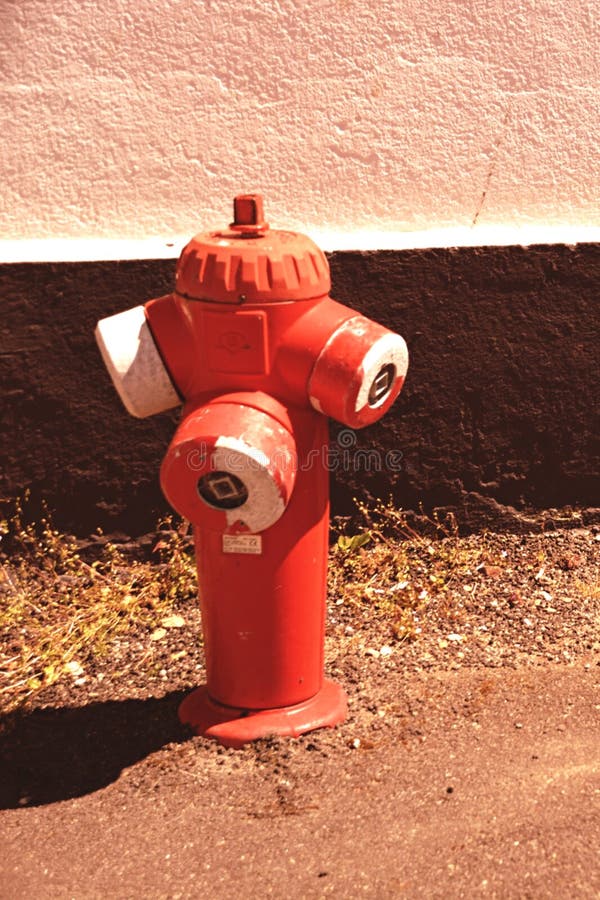 A Fire Hydrant Sitting on the Side of a Building Stock Photo - Image of ...