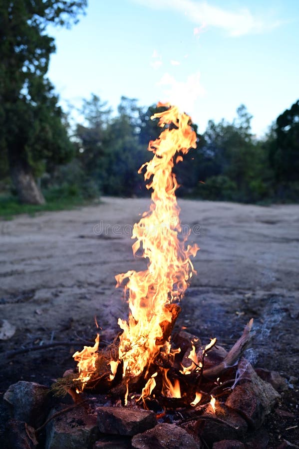 A Fire that is Next To Some Rocks and Water in the Ground Stock Photo ...