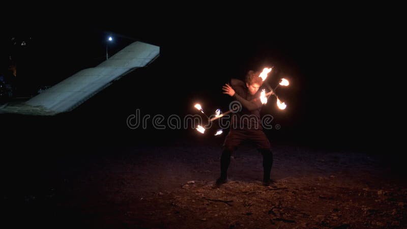Fire Show Artist Guy Twists a Fire Pole Around His Body Under a Bridge ...