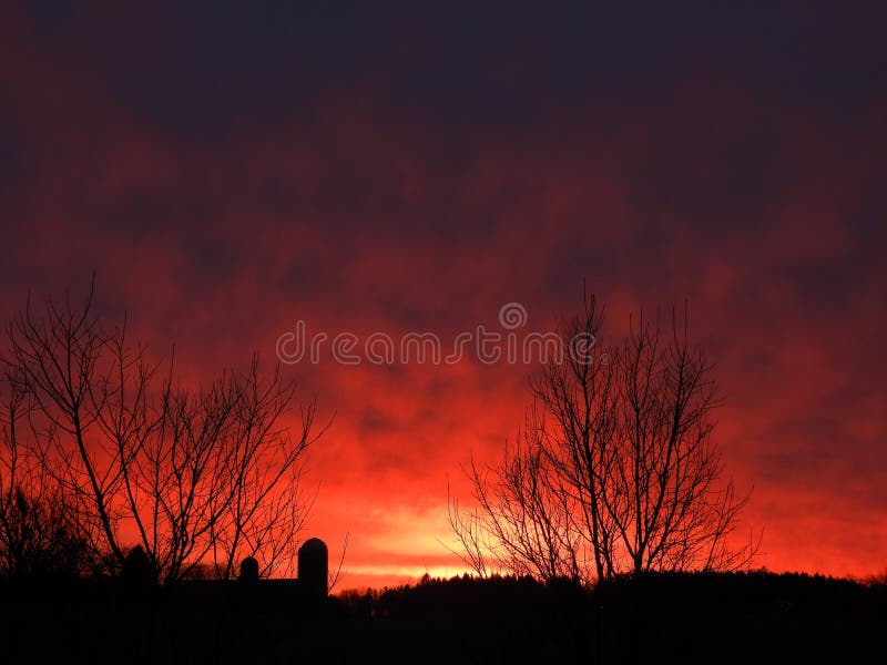 Red Fiery Sky Lights Up Behind Farm Buildings Stock Photo - Image of ...