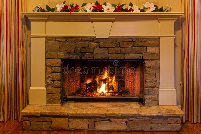 Fire in a Stone Fireplace Decorated with Red and White Flowers. Stock ...