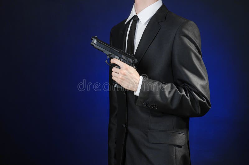 Firearms and Security Topic: a Man in a Black Suit Holding a Gun on a ...