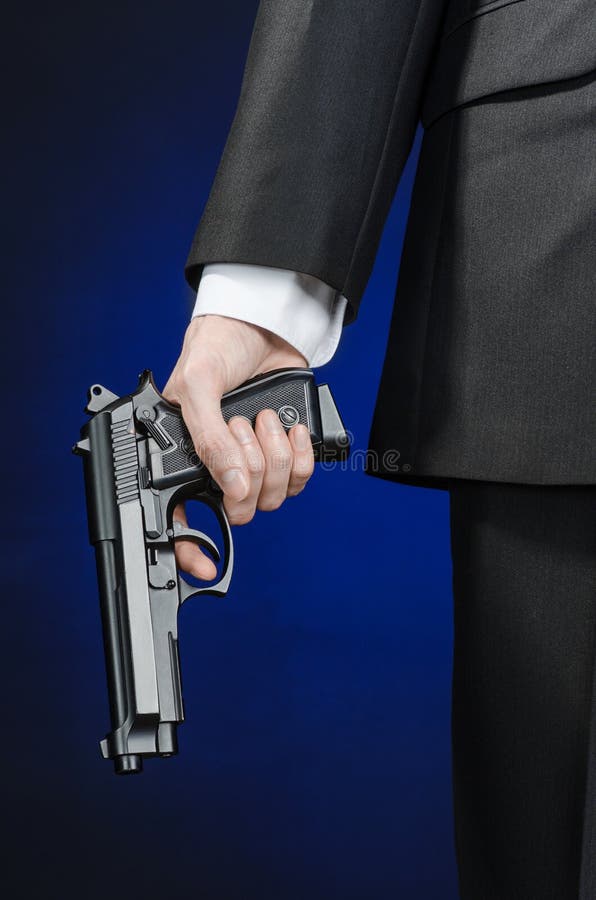 Firearms and Security Topic: a Man in a Black Suit Holding a Gun on a ...