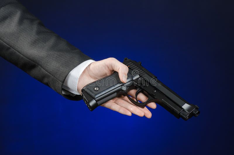 Firearms and Security Topic: a Man in a Black Suit Holding a Gun on a ...