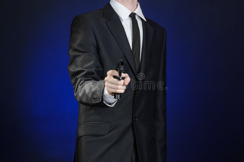 Firearms and Security Topic: a Man in a Black Suit Holding a Gun on a ...