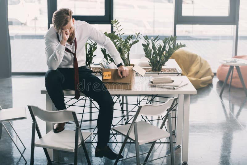 Fired Businessman with Cardboard Box Sitting on Table in Office Stock ...